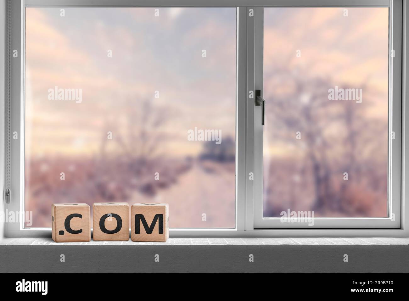 Com sign in a bright window with a view to a road going through a ...