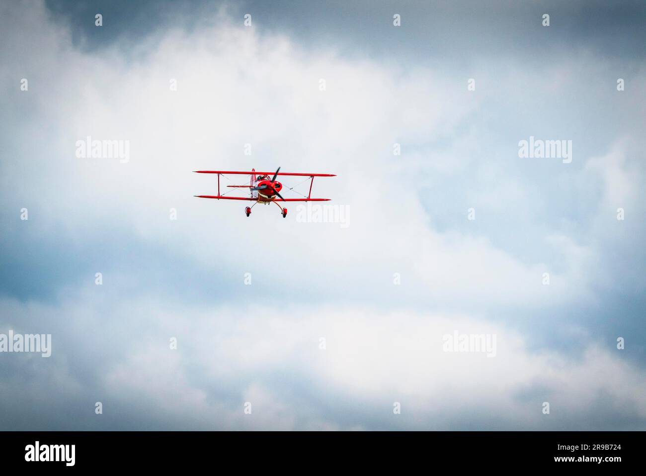 Vintage red propeller plane flying on a blue sky with front Stock Photo ...