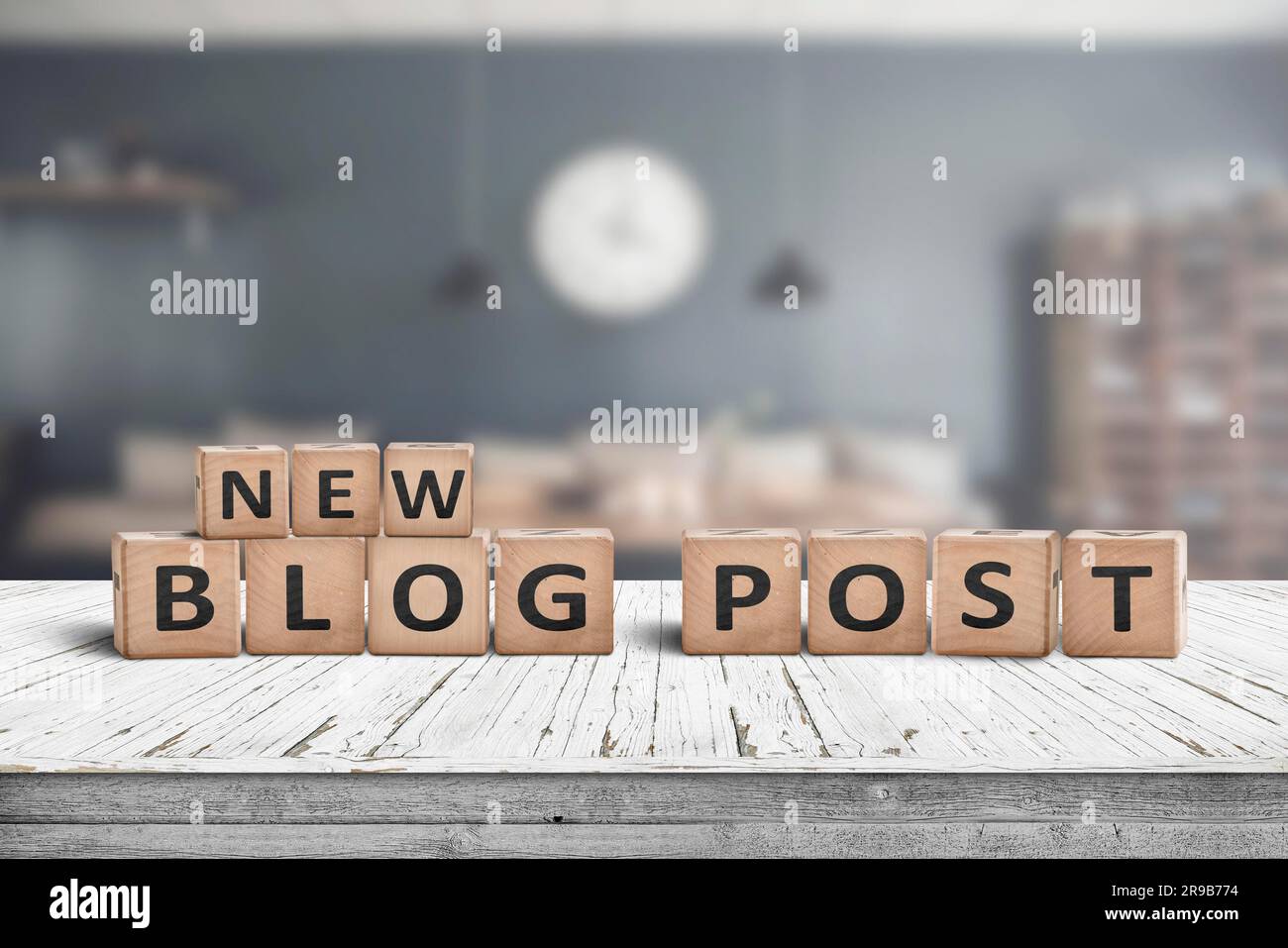New blog post sign on a wooden desk with a stylish living room on a ...