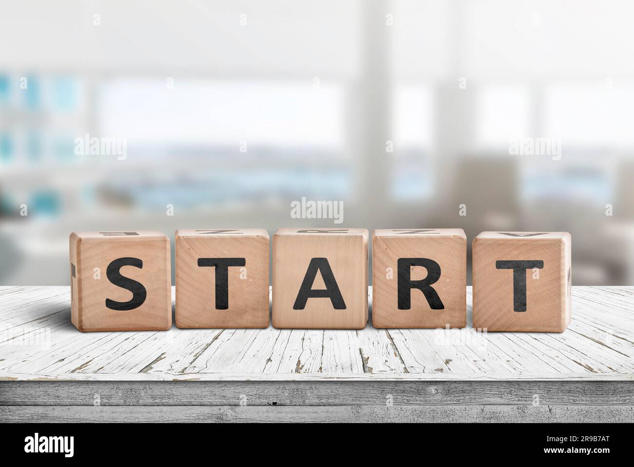 Start sign in a bright office on a wooden table with white worn planks ...
