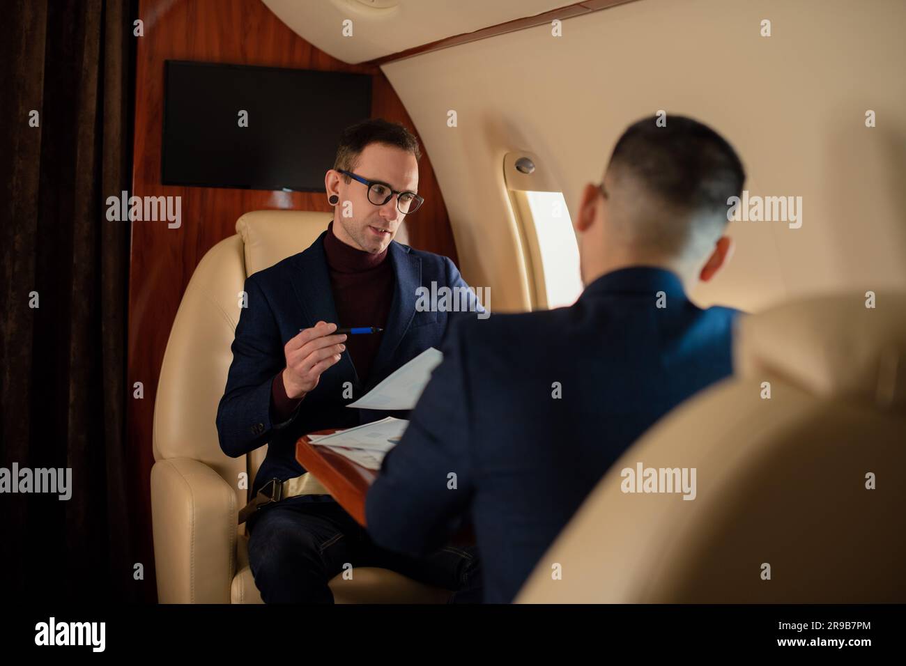 Elegant Businessman couple sitting inside a private airplane jet and ...