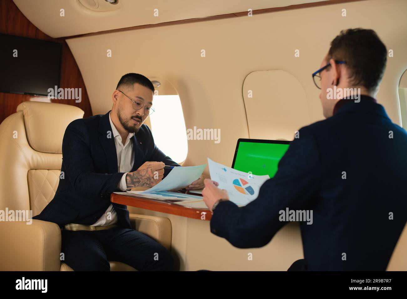 Two Businessman CEO couple in eyeglasses sitting inside a private jet ...