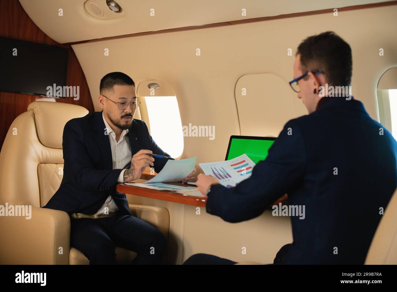 Two Businessman CEO couple in eyeglasses sitting inside a private jet ...