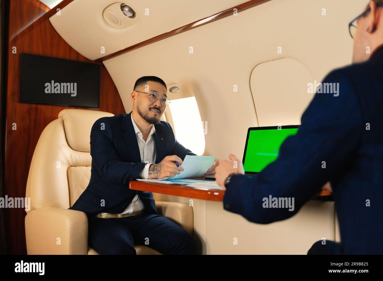 Two Businessman CEO couple in eyeglasses sitting inside a private jet ...