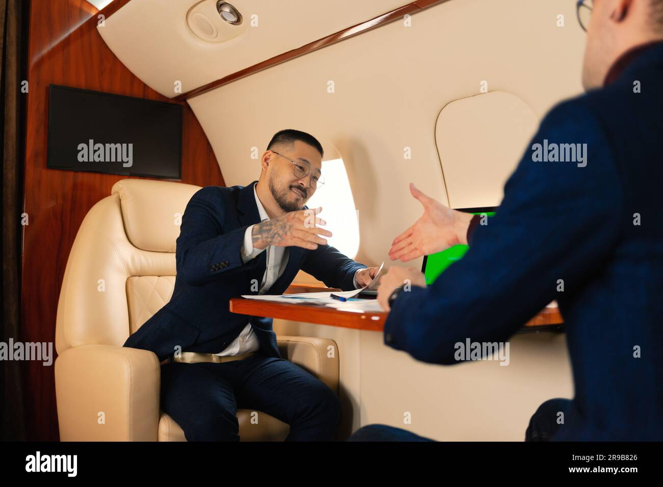 Two Businessman CEO couple in eyeglasses sitting inside a private jet ...