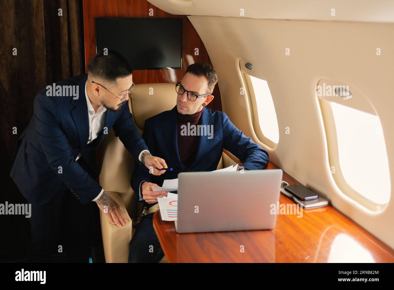 Two Businessman couple sitting inside a private jet airplane and ...
