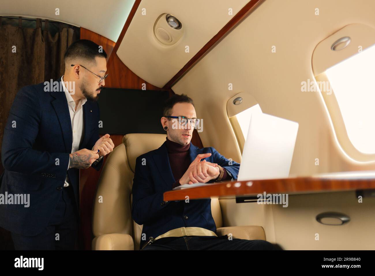 Two Businessman couple sitting inside a private jet airplane and ...