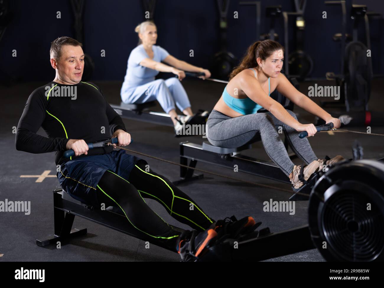 Athlete is engaged in the gym, man works on rowing simulator Stock ...