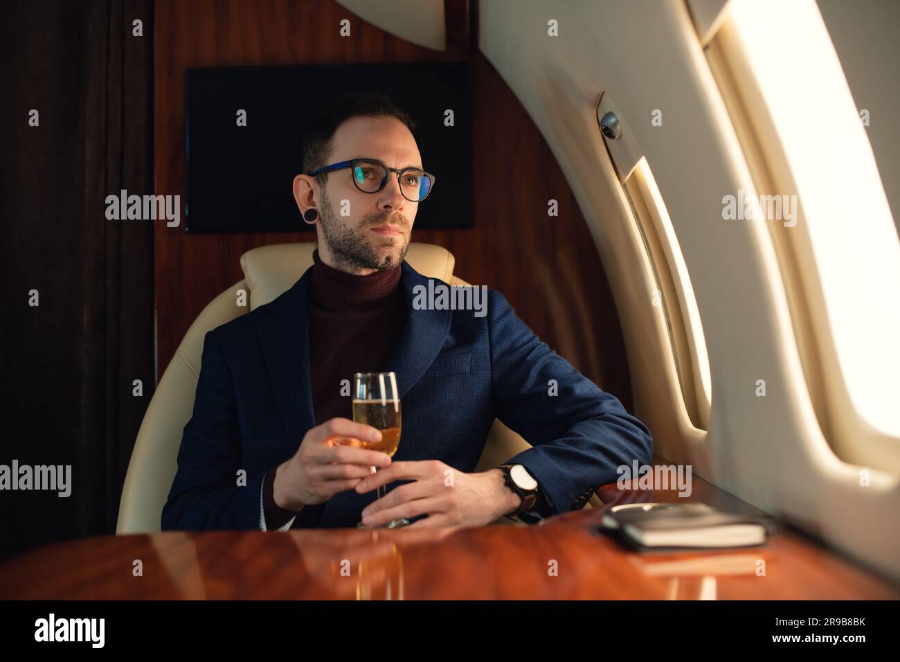 Elegant young CEO businessman in eyeglasses in jacket sitting inside a ...