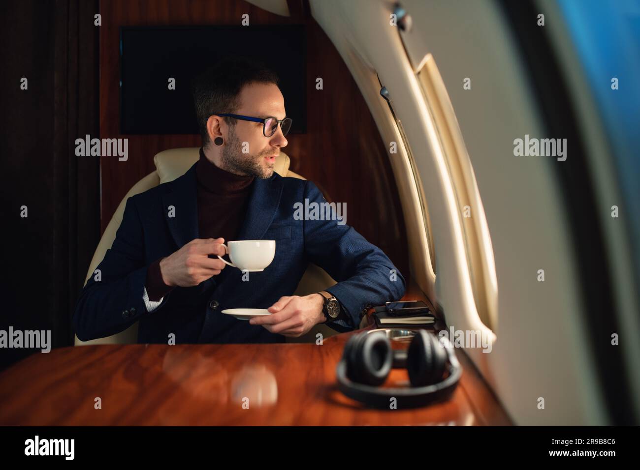 Elegant CEO young businessman in eyeglasses a jacket sitting inside in ...