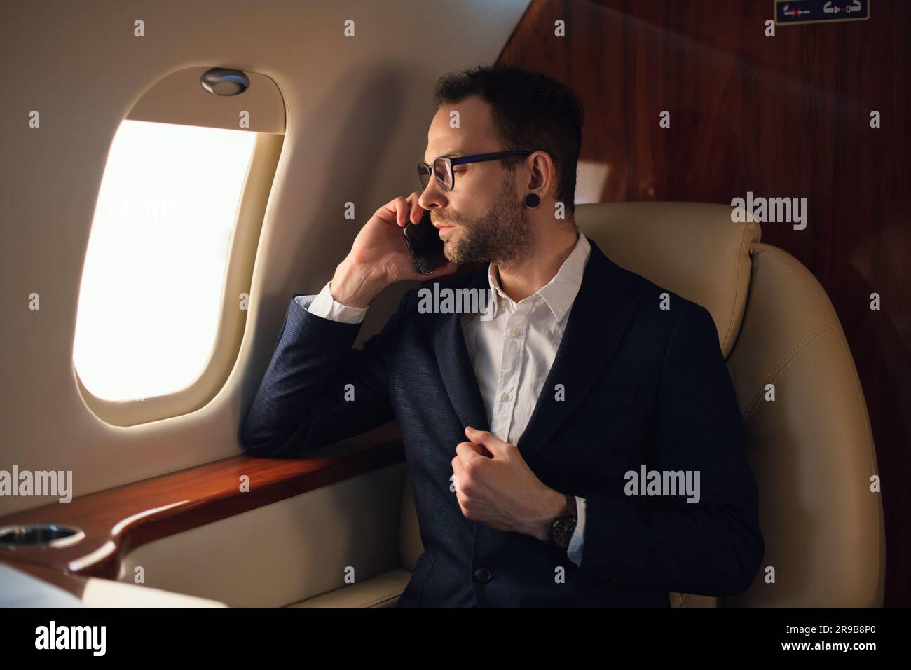 Elegant Young CEO Businessman in eyeglasses talking on a smartphone ...