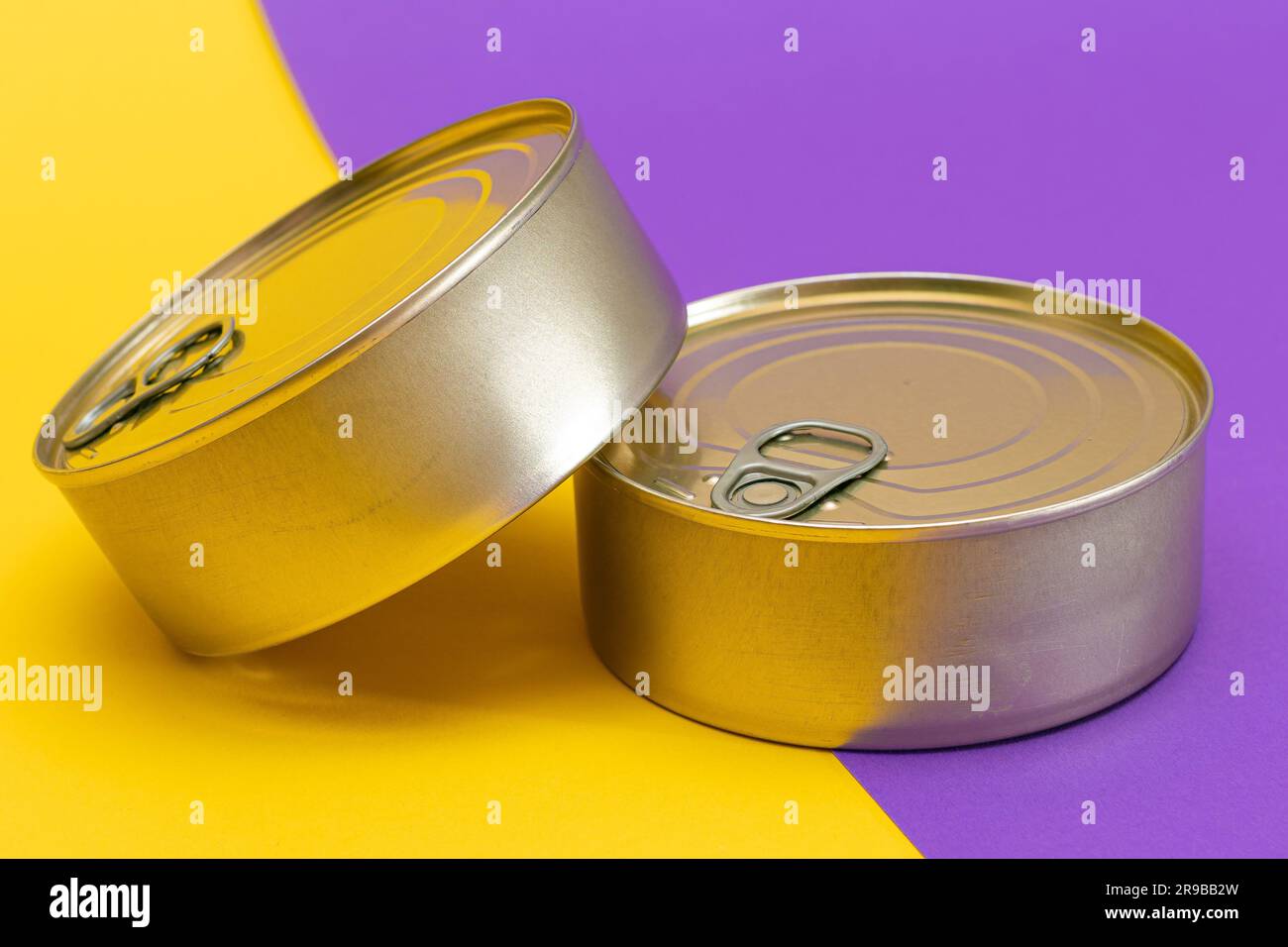 A Group of Stacked Tin Cans with Blank Edges on Split Yellow and Violet ...
