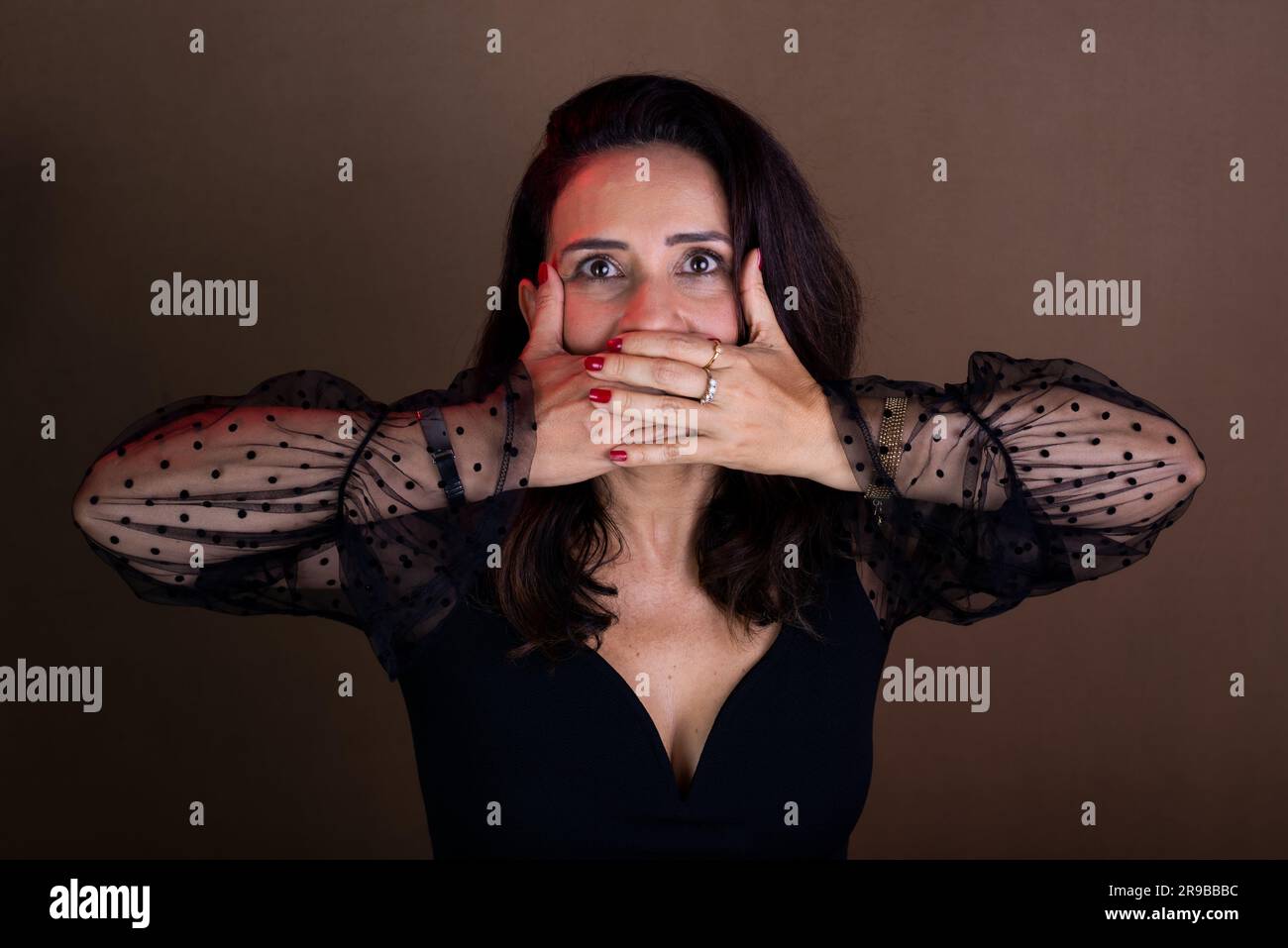 Coaching woman in black clothing with hands covering her mouth in a ...