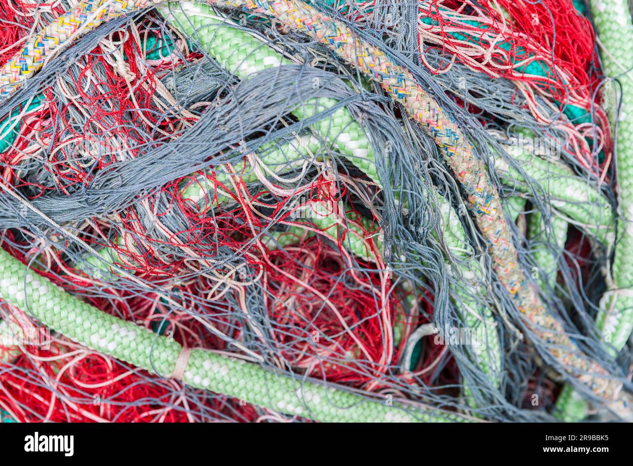 green marine rope and tangled red fishing net close-up in. pile Stock ...