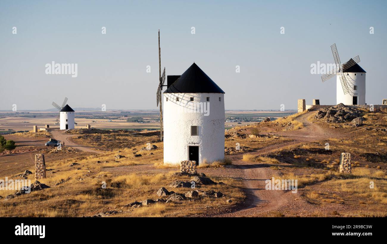 Three traditional windmills stand majestically atop a rolling hill ...