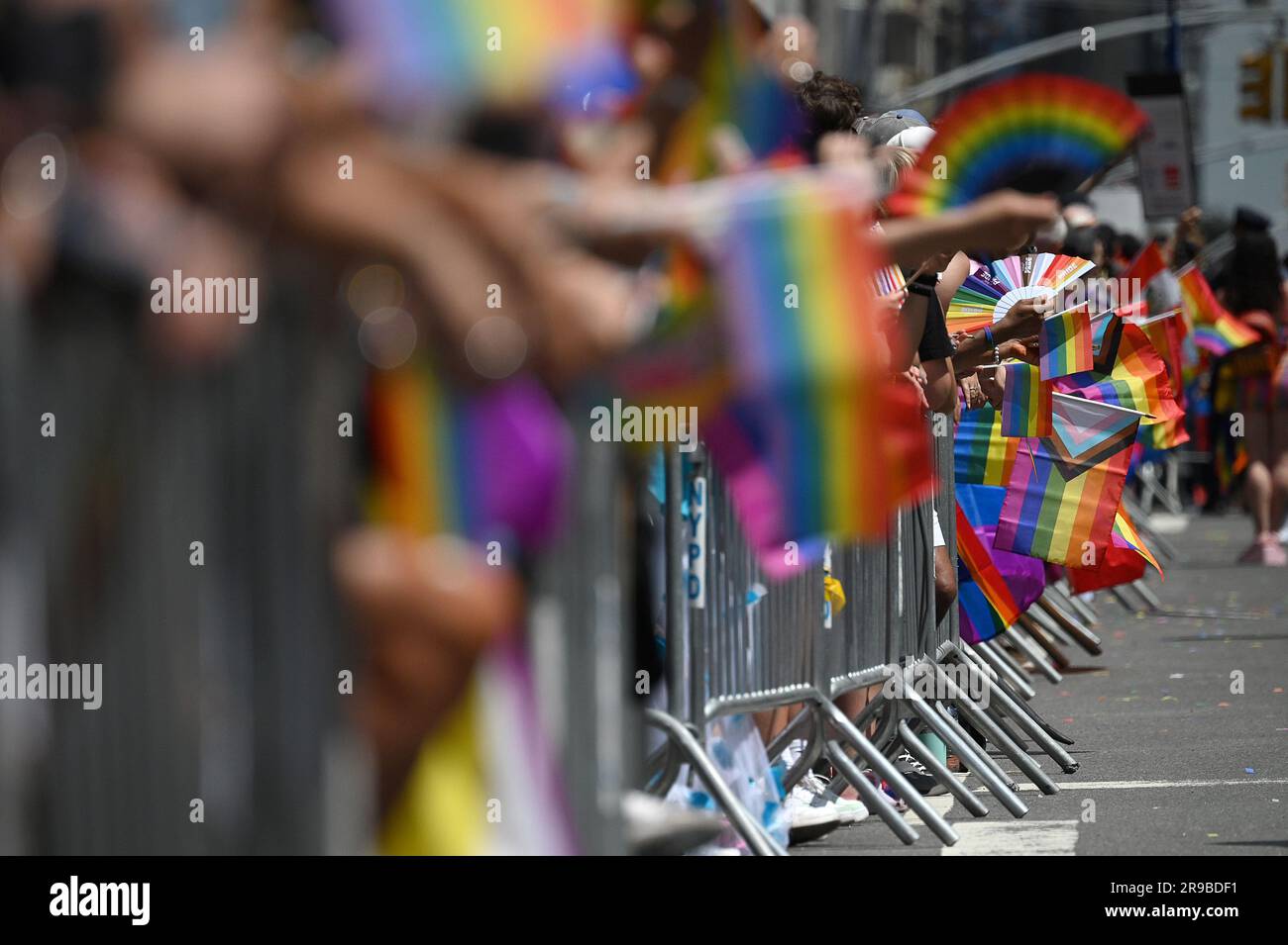 New York, USA. 25th June, 2023. Parade-goers hold pride-themed flags as ...