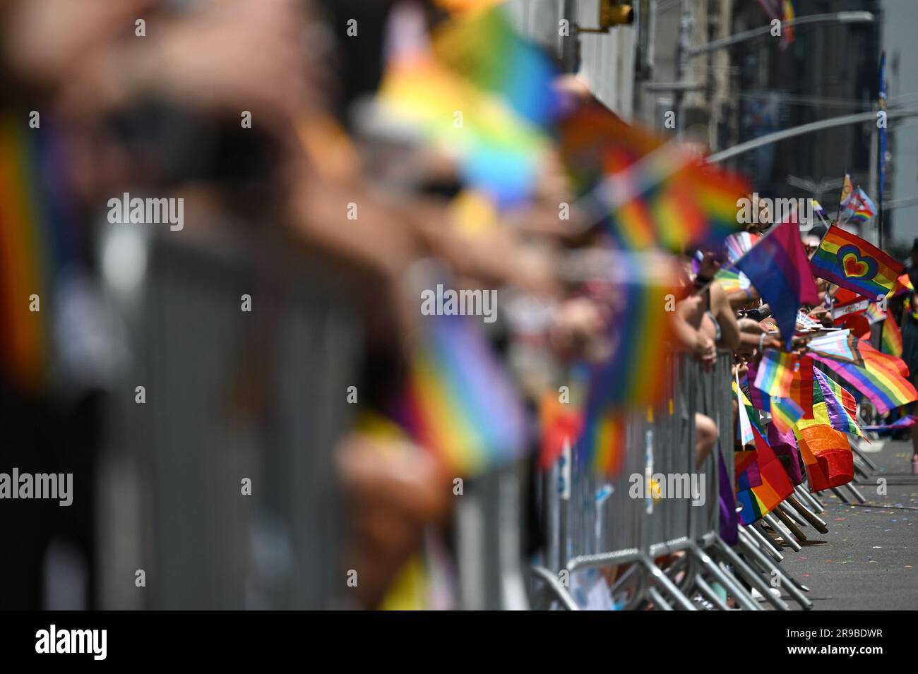 New York, USA. 25th June, 2023. Parade-goers hold pride-themed flags as ...