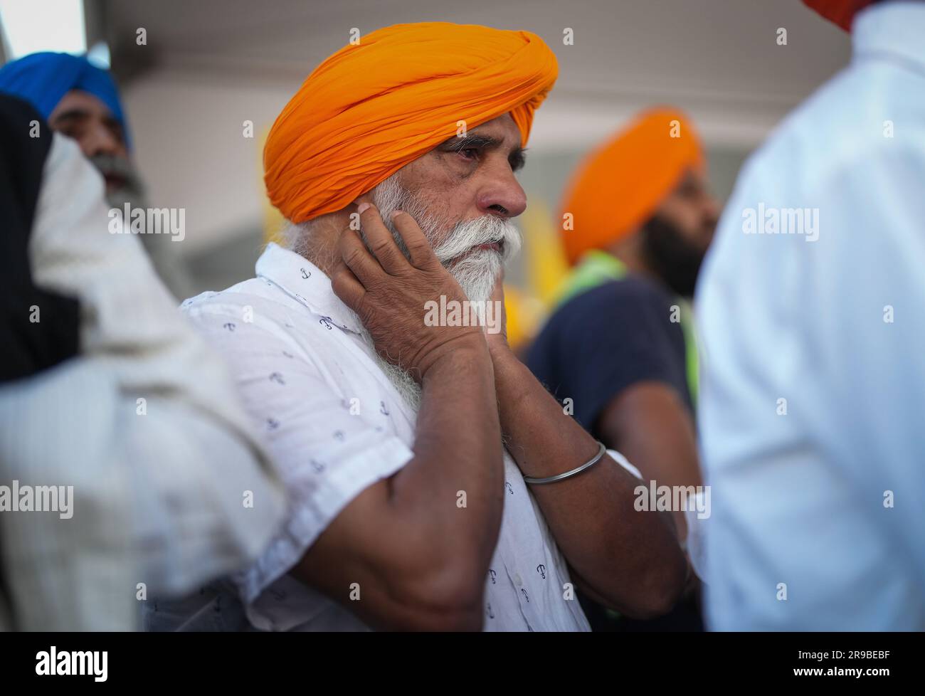 Surrey, Canada. 25th June, 2023. A man listens while mourning Sikh community leader and temple ...