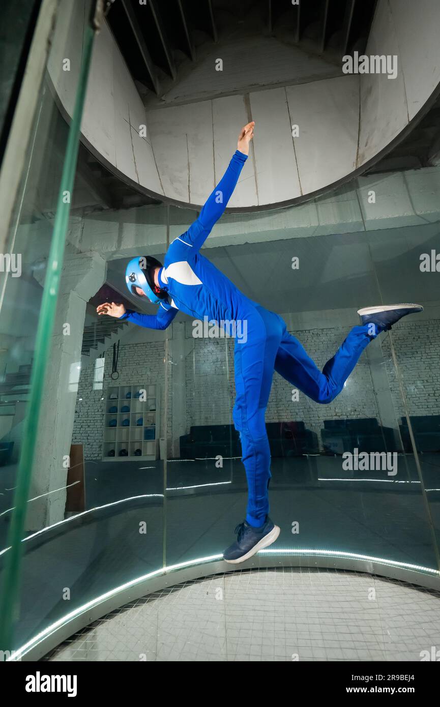 A man in overalls and a protective helmet enjoys flying in a wind ...