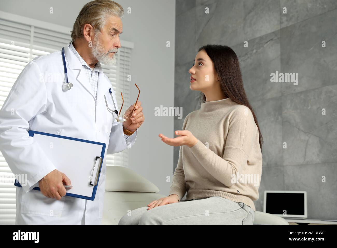 Patient having appointment with senior doctor in clinic Stock Photo - Alamy