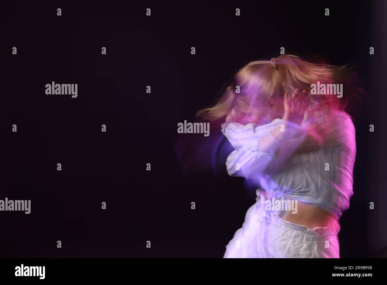 Young woman performing contemporary dance on black background, motion ...