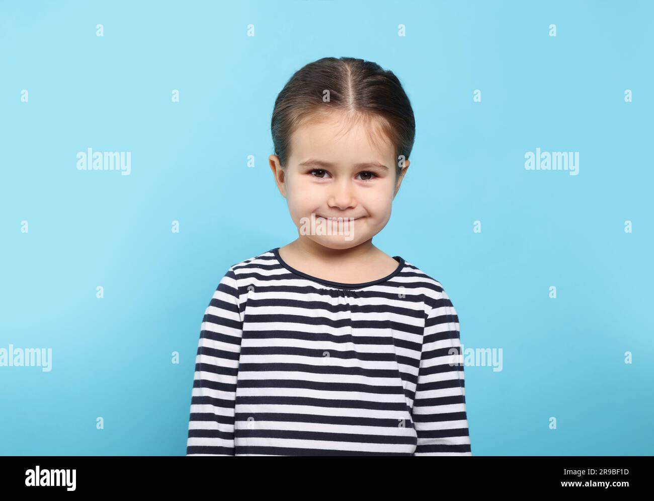Beautiful happy girl on light blue background Stock Photo - Alamy