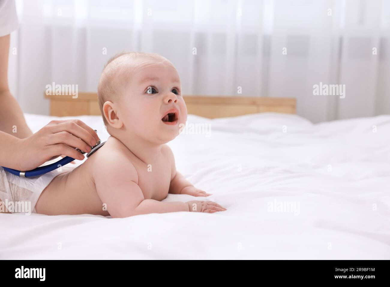 Pediatrician examining cute little baby with stethoscope in clinic ...