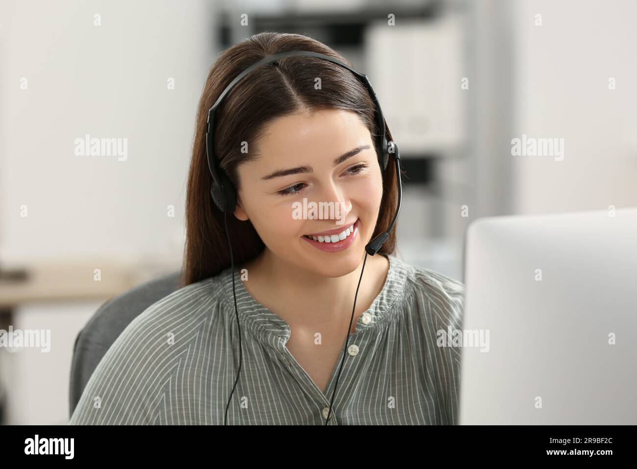 Hotline operator with headset working on computer in office Stock Photo ...