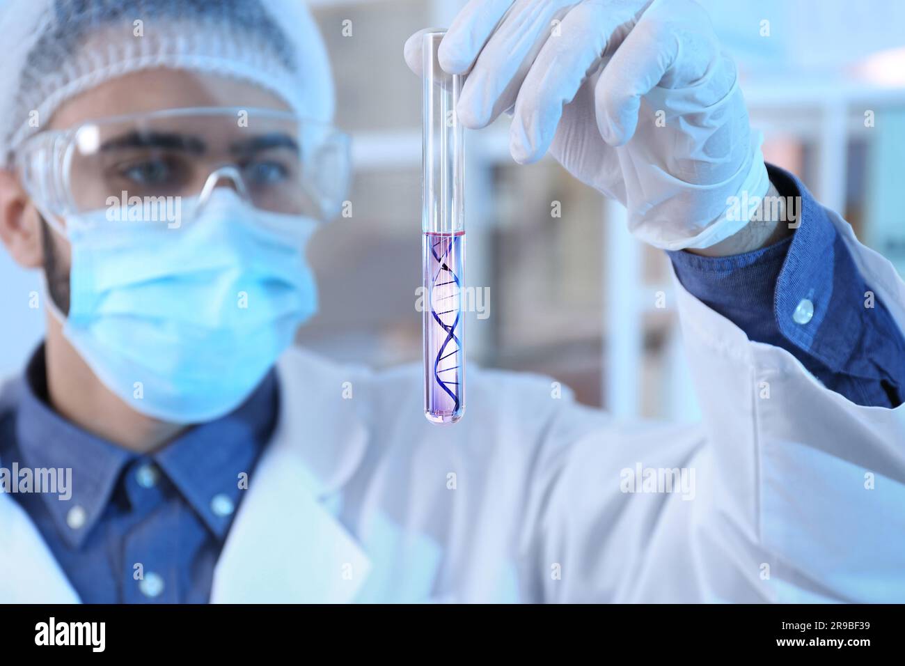 Genetics research. Scientist holding test tube with liquid and ...