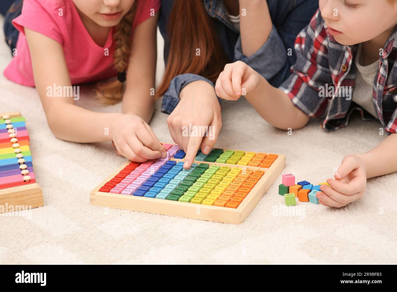 Mother and children playing with different colorful cubes and equations ...