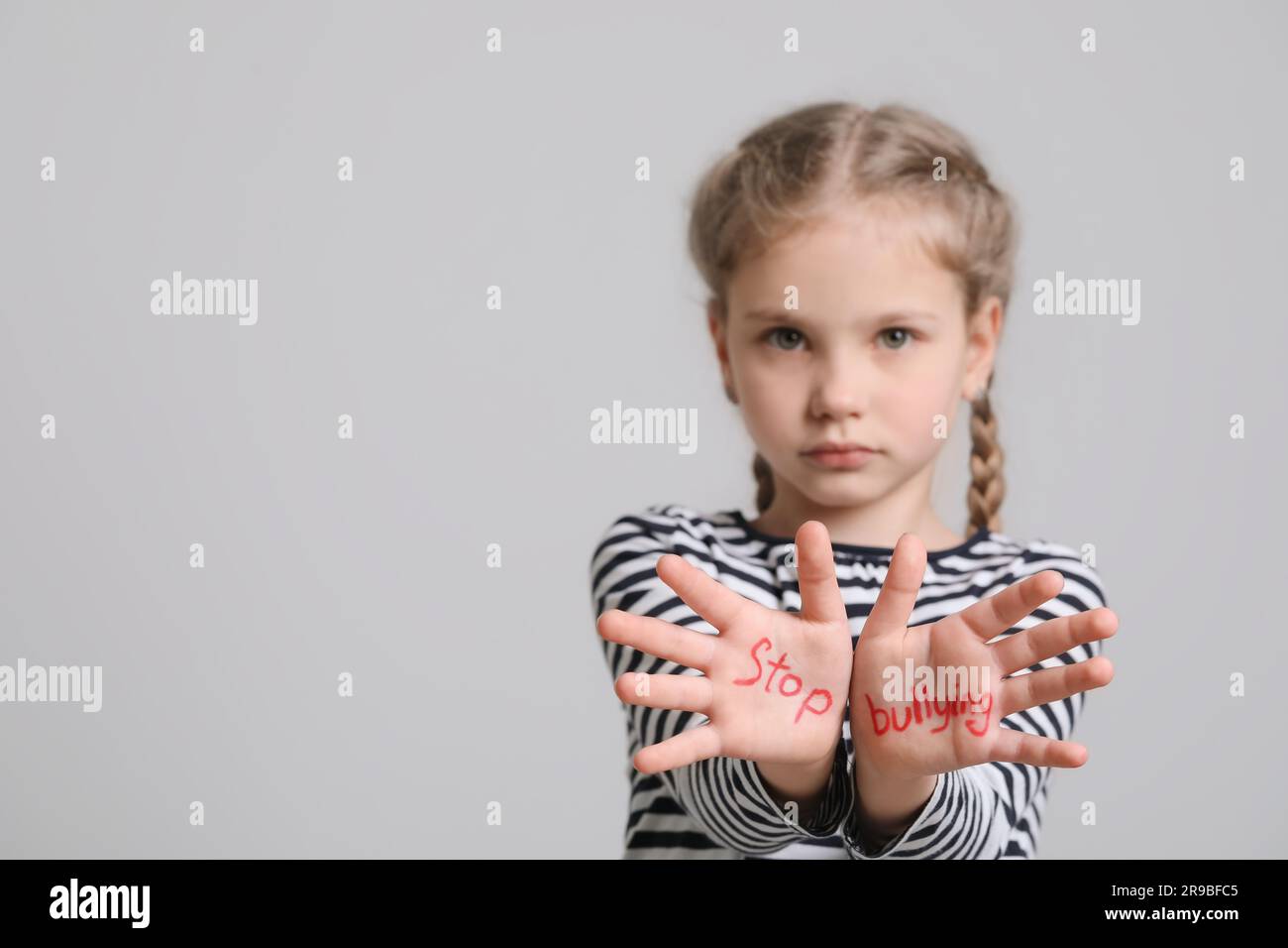 Girl showing hands with phrase Stop Bullying on light grey background ...