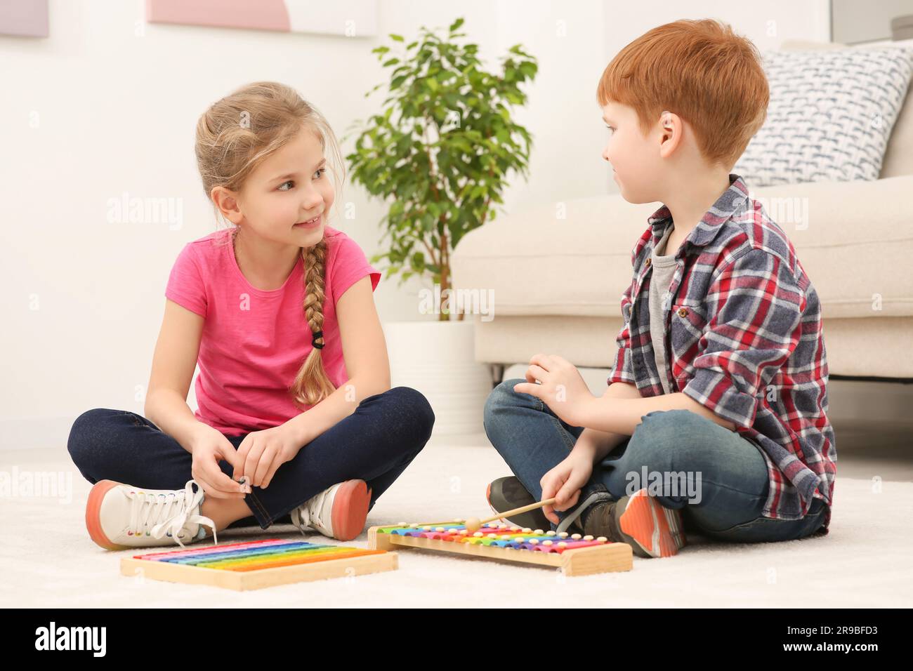 Children playing with different math game kits on floor in living room ...