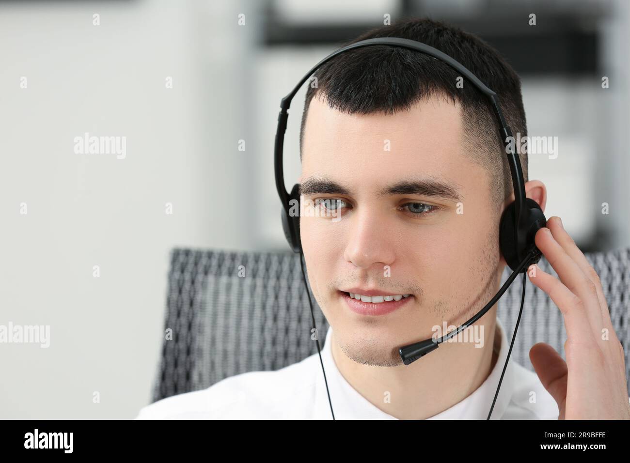 Hotline operator with headset working in office, space for text Stock ...