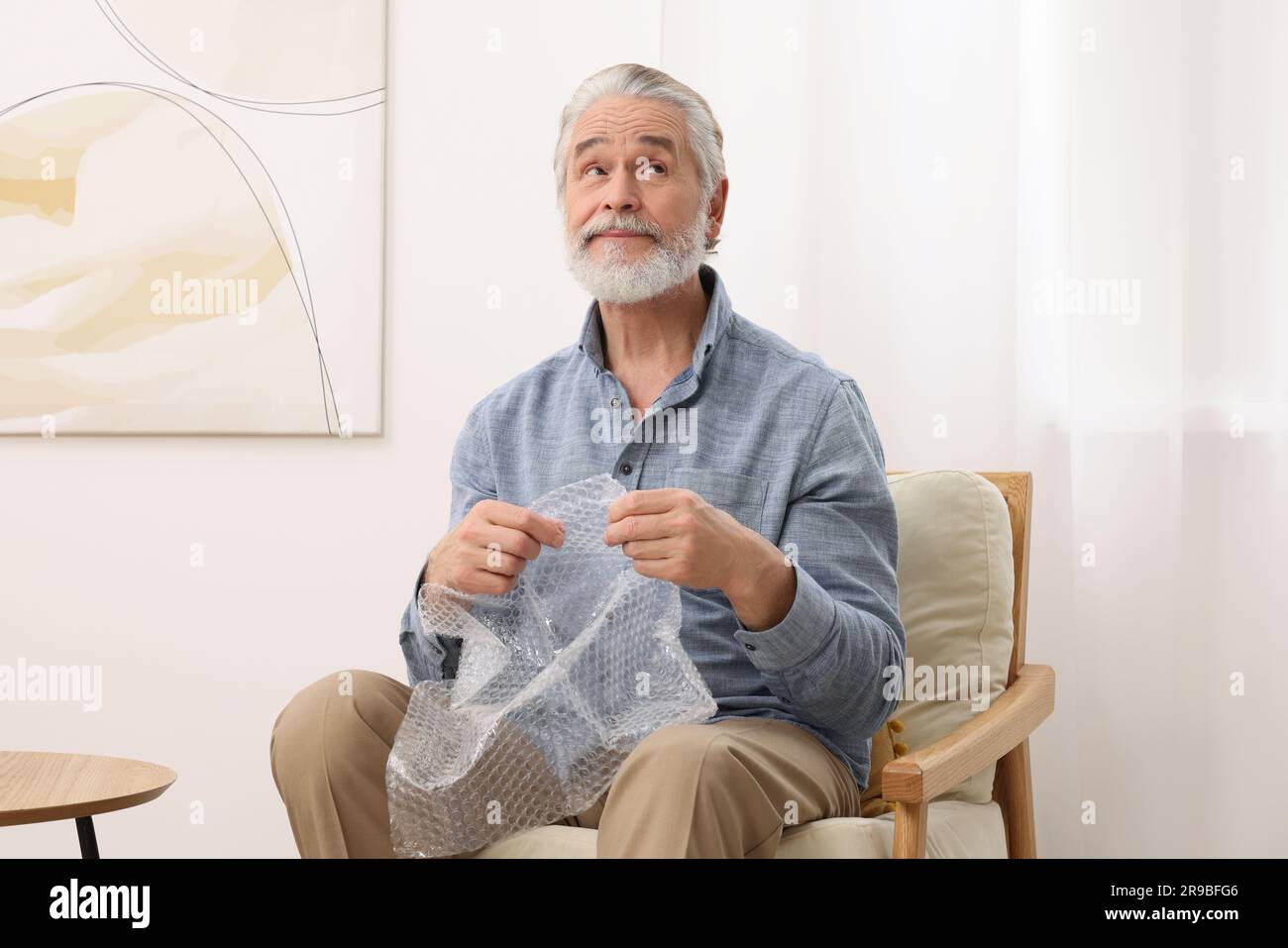 Happy senior man popping bubble at home. Stress relief Stock Photo - Alamy