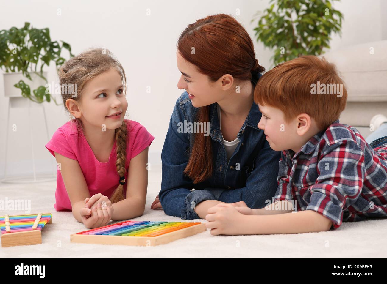 Happy mother and children playing with different math game kits on ...