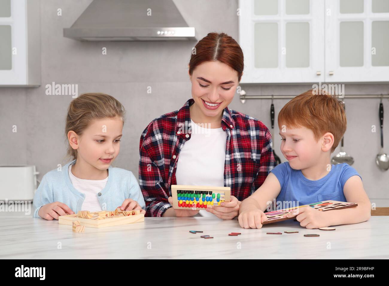 Happy mother and children playing with different math game kits at ...