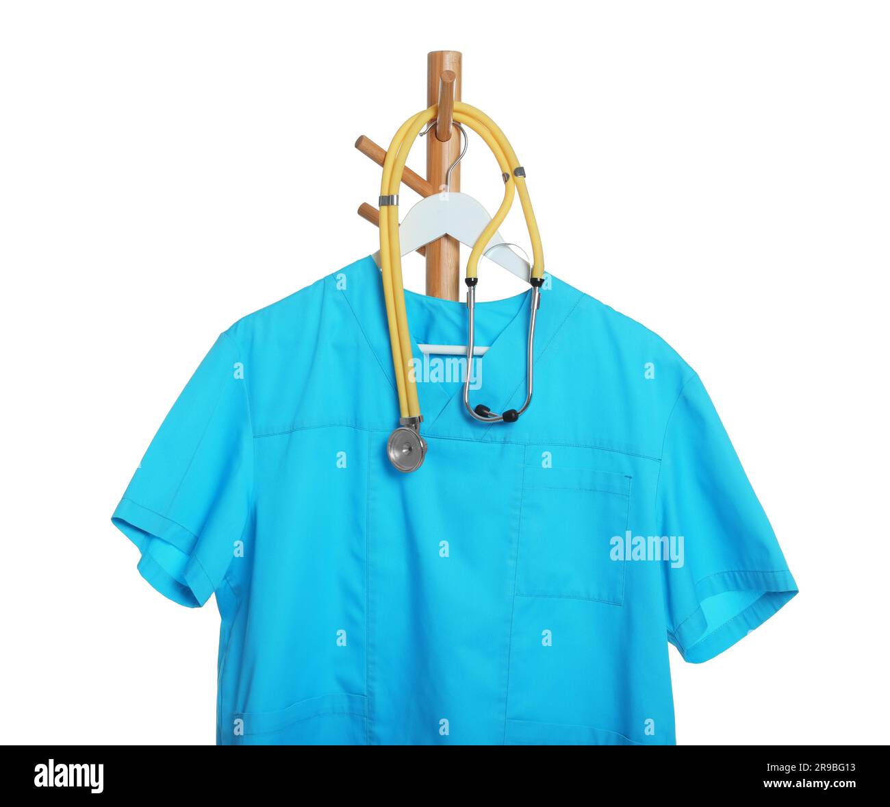 Turquoise medical uniform and stethoscope on rack against white ...