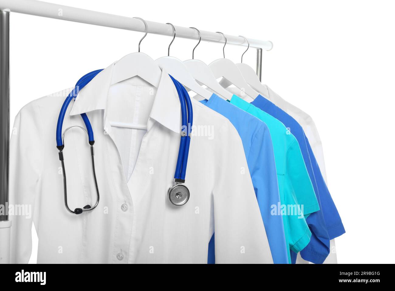 Doctor's gown with stethoscope and different medical uniforms on rack ...
