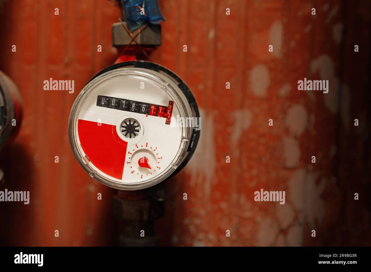 Electric meter near red brick wall, space for text. Water measuring ...