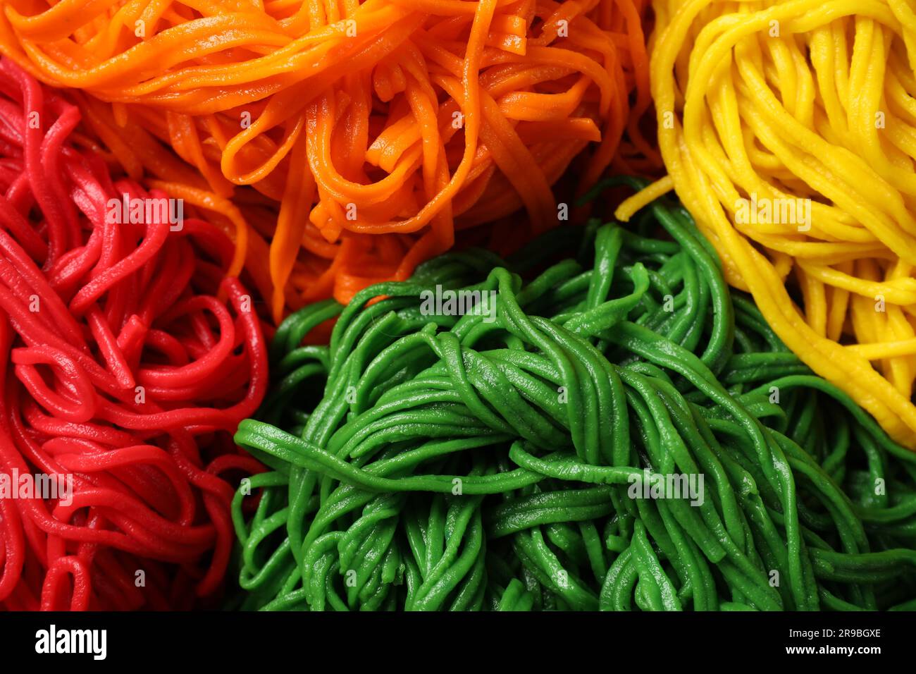 Rolled spaghetti painted with different food colorings as background ...