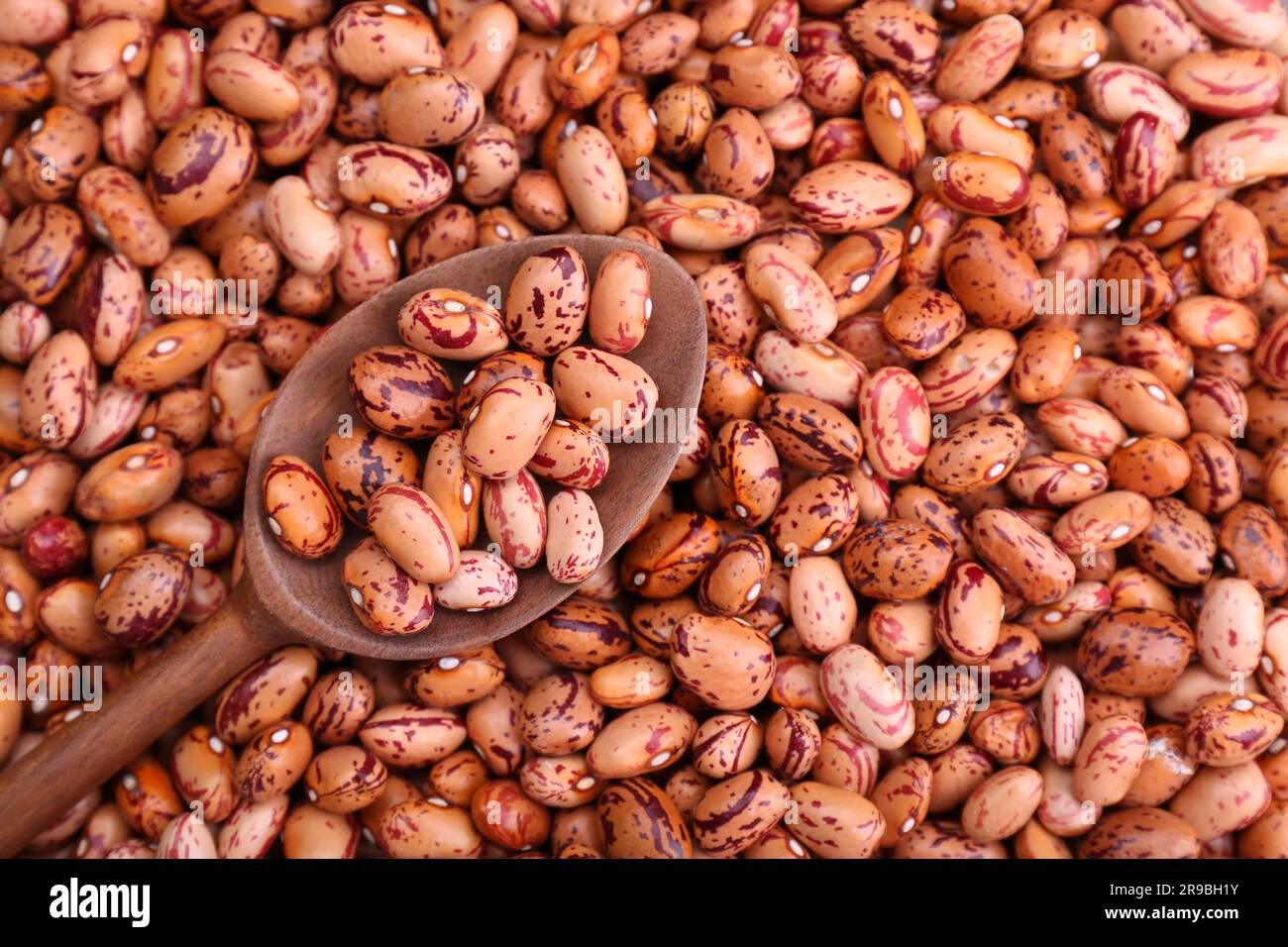 Wooden spoon on dry kidney beans, top view Stock Photo - Alamy