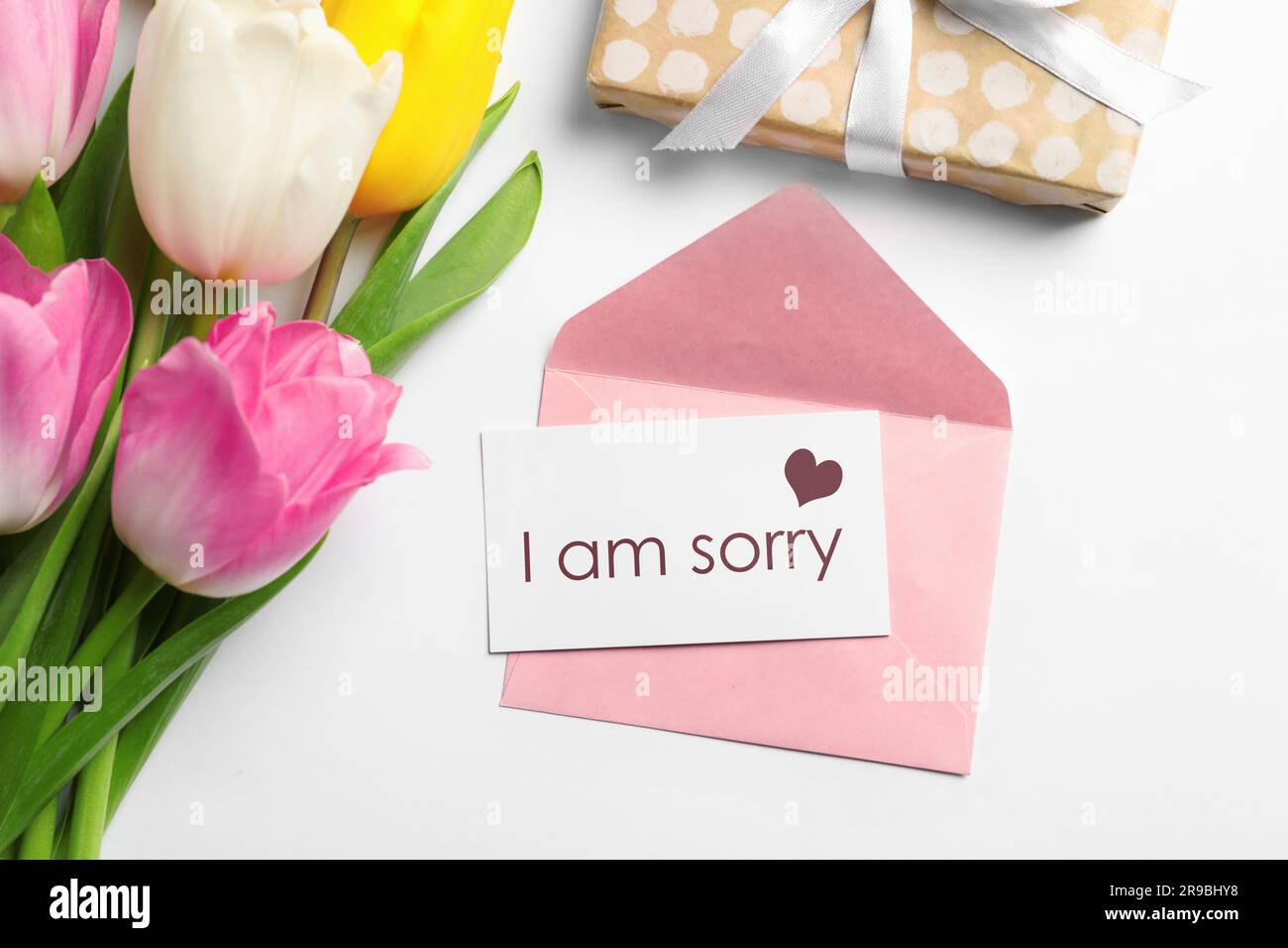 Card with phrase I Am Sorry, pink envelope, bouquet of tulips and gift ...