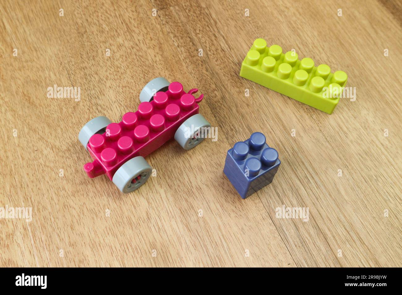 Plastic building blocks on wooden background Stock Photo - Alamy