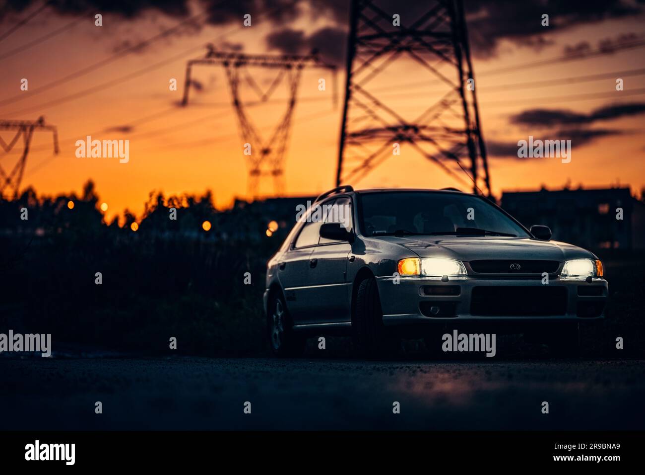A Subaru Impreza Outback parked on the side of a street at dusk, with ...