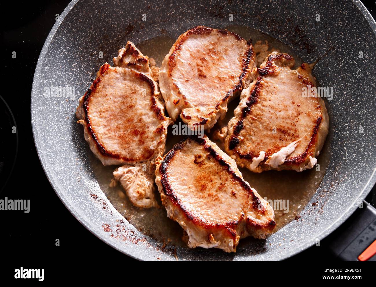 Fried pork steak in frying pan Stock Photo - Alamy