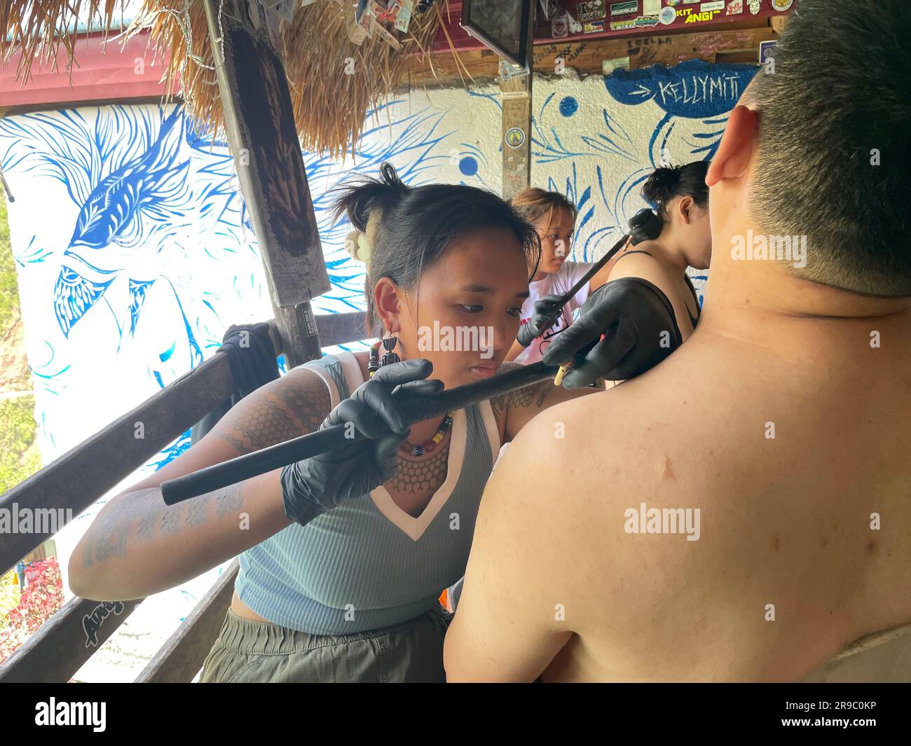 Buscalan, Philippines. 24th May, 2023. Grace Palicas (l) and Elyang Wigan (back) tattoo visitors ...