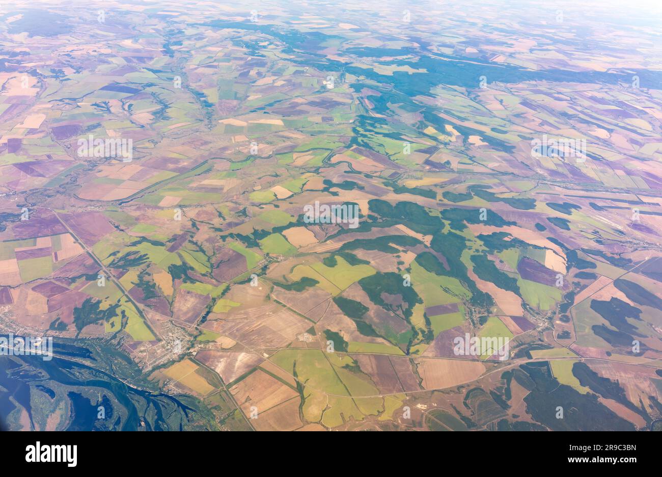 Aerial view from airplane window above green ground. View from the ...