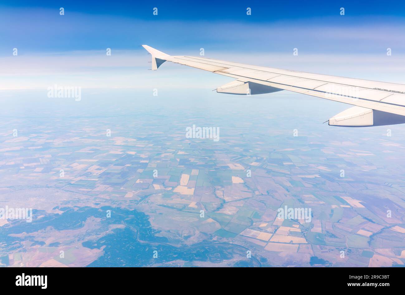 Aerial view from airplane window above green ground. View from the ...