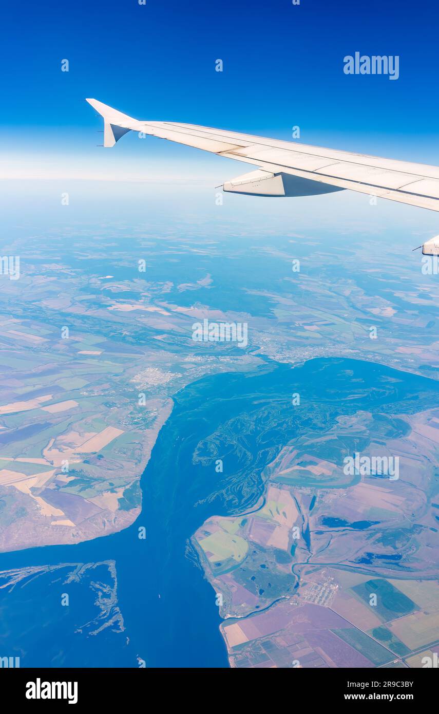 Aerial view from airplane window above green ground. View from the ...