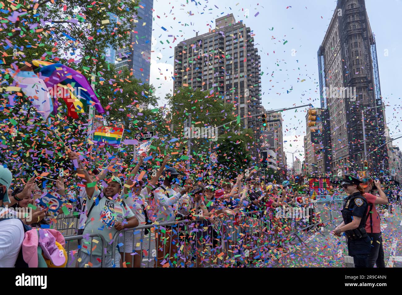 NEW YORK, NEW YORK - JUNE 25: Spectators with pride flags watch the ...
